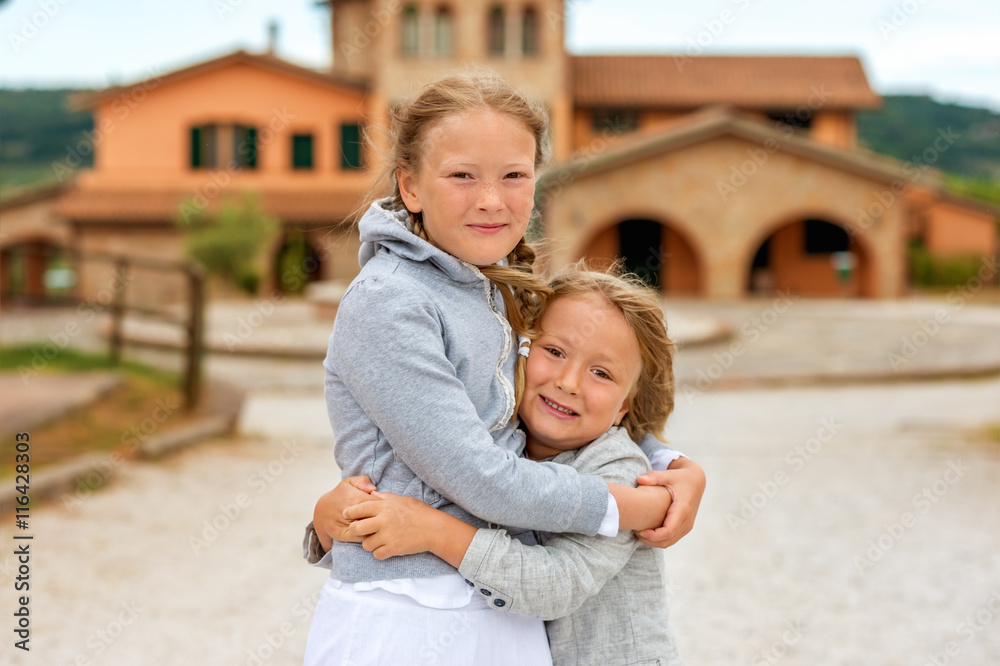 Two adorable kids playing outdoors on a very windy day. Image taken in ...