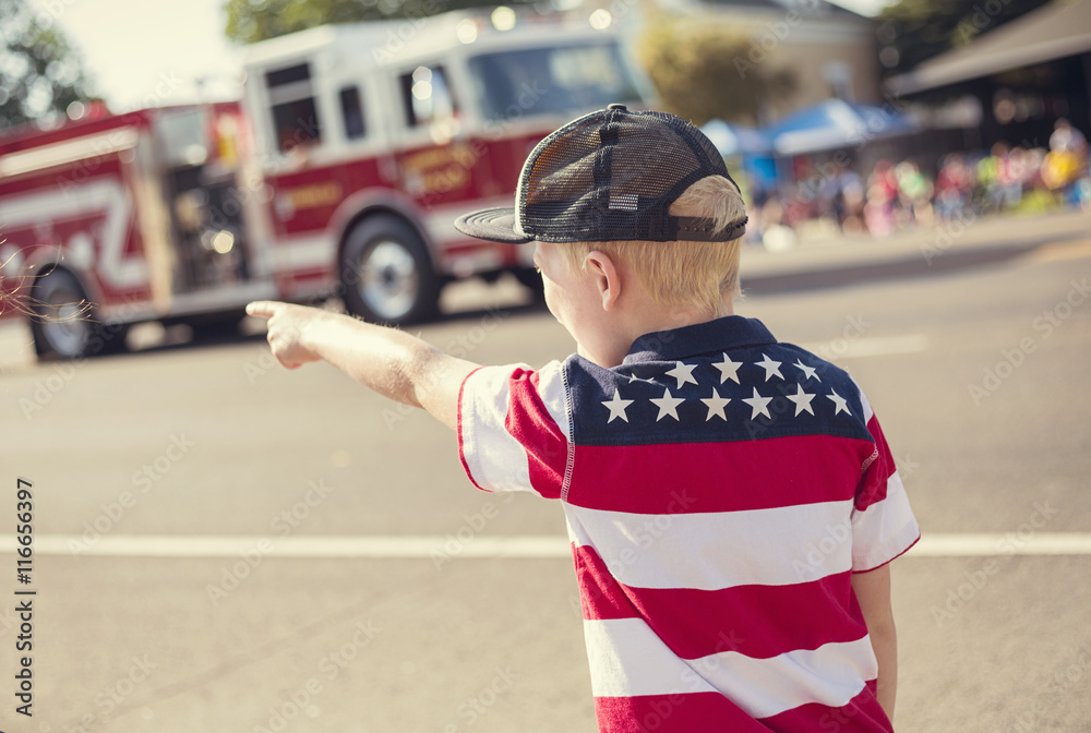 Boy watching a firetruck drive by during a parade procession during an ...