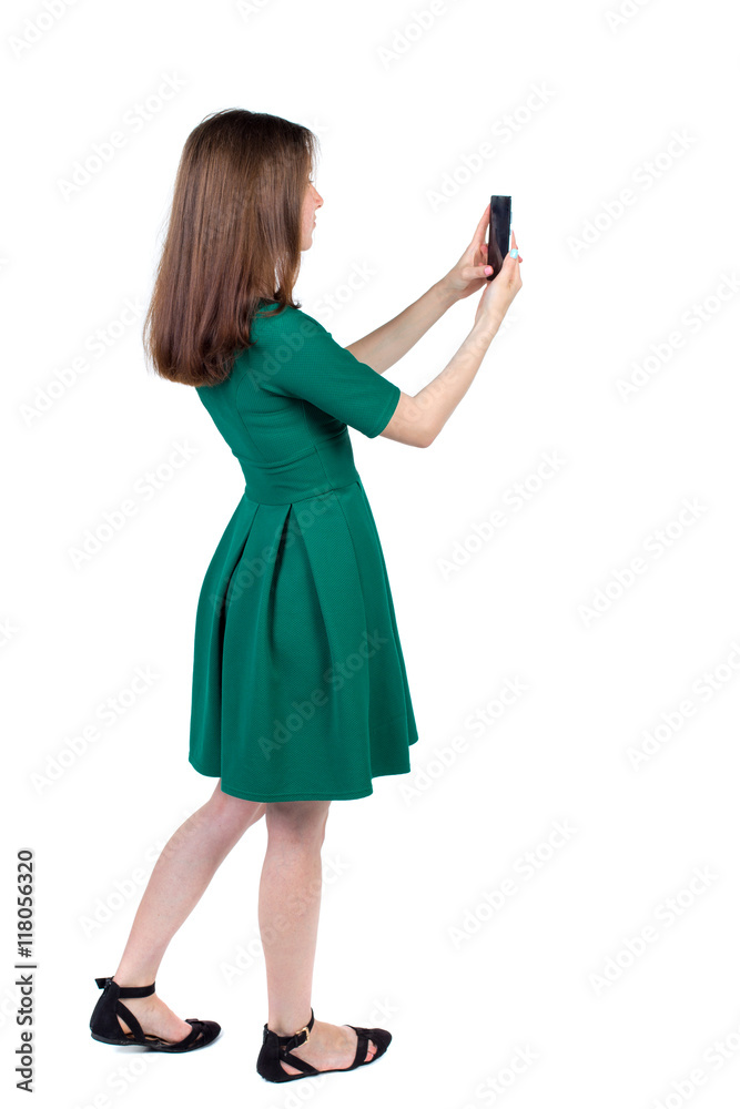 back view of standing young beautiful woman using a mobile phone. girl ...