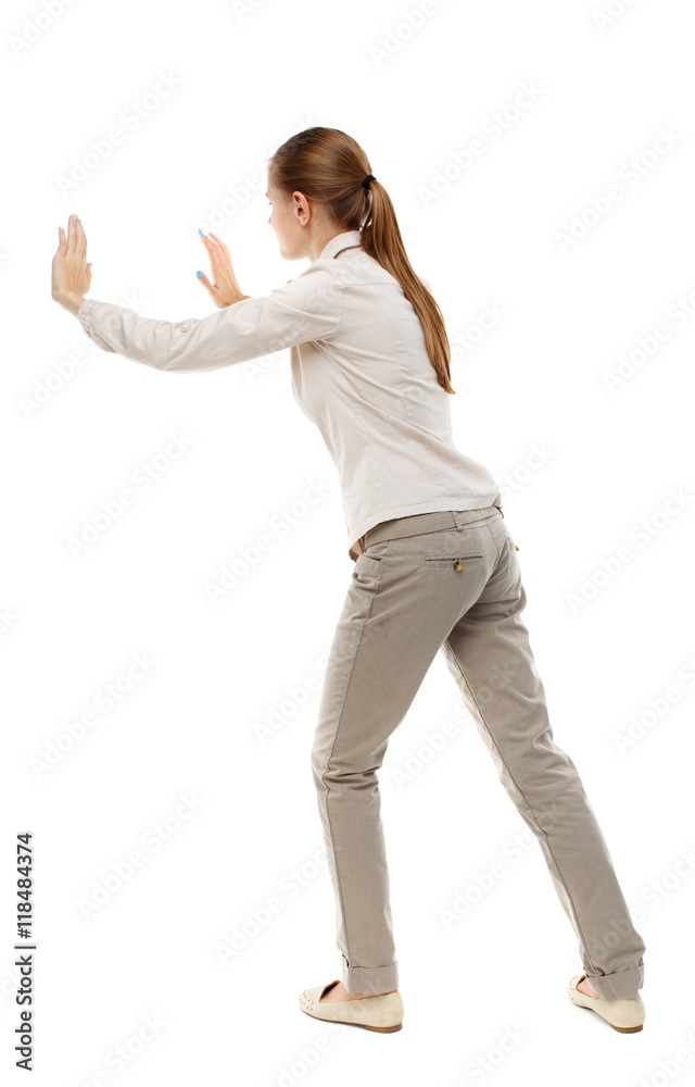 back view of woman pushes wall. Isolated over white background. Rear ...