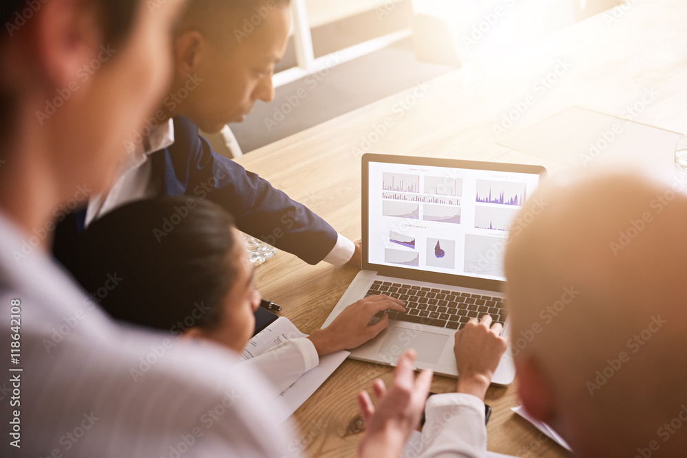 Stock-Foto „Group of four people pointing to and analysing graphs and ...