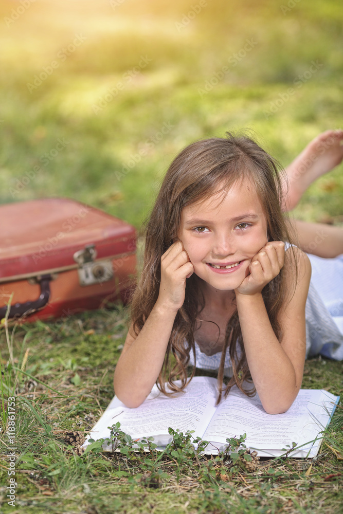 cute girl reading a book outdoors Stock Photo | Adobe Stock