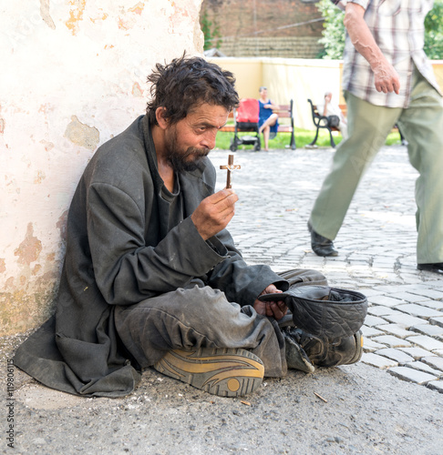 Homeless dirty man with cross on the street of the city Stock Photo ...