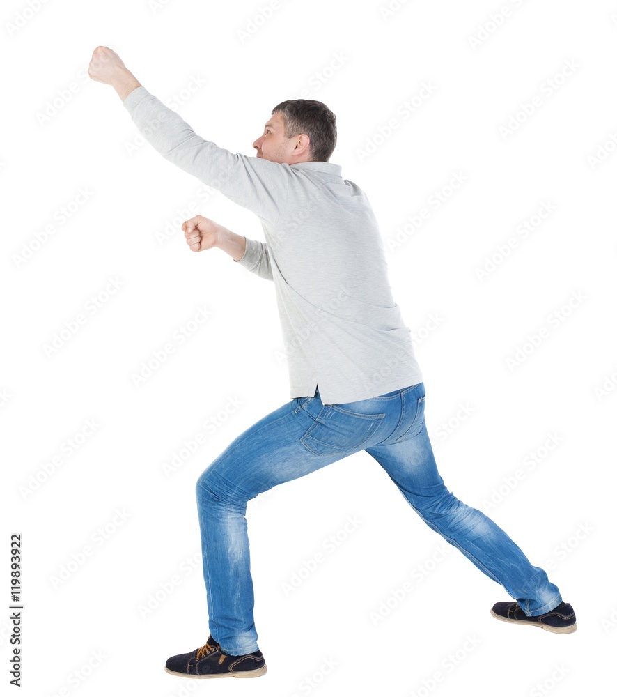 back view of standing man pulling a rope from the top or cling to ...