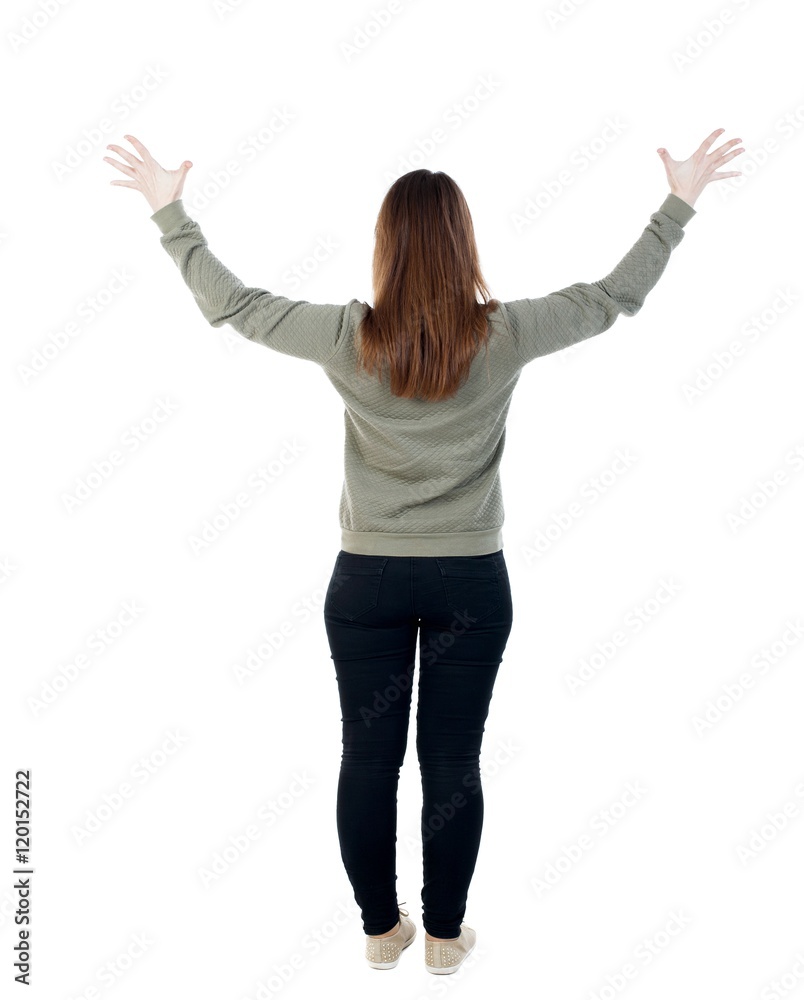 Back view of Beautiful woman looking at wall and Holds hand up. young ...