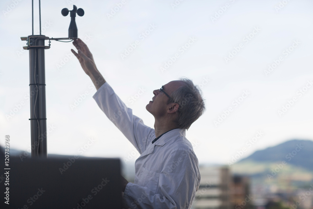 Male meteorologist measuring wind using anemometer at weather station ...