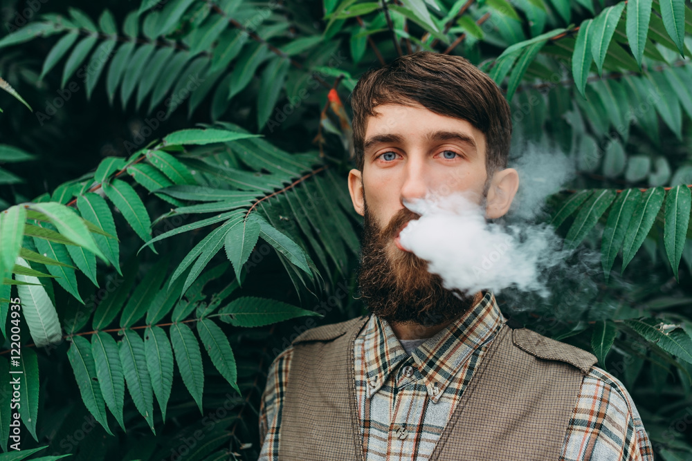 Young man with beard vaping an electronic cigarette outdoor. hipster smoke vaporizer. Stock ...