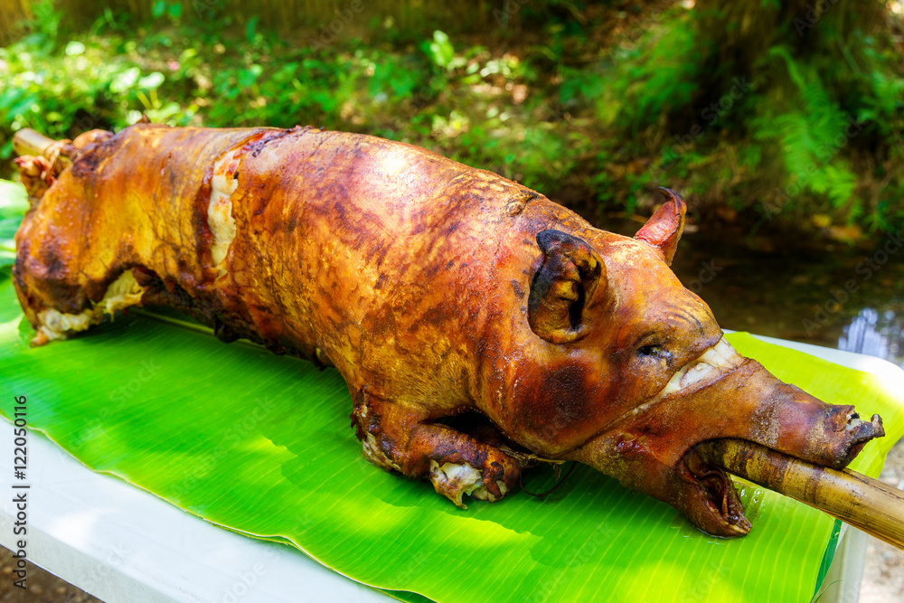Fire-roasted suckling pig served on banana leaves. Filipino food Stock ...