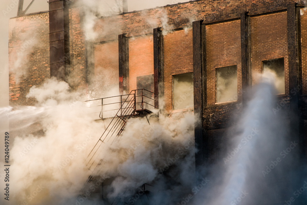 Smoke enveloping staircase while firefighters spray water into burning ...