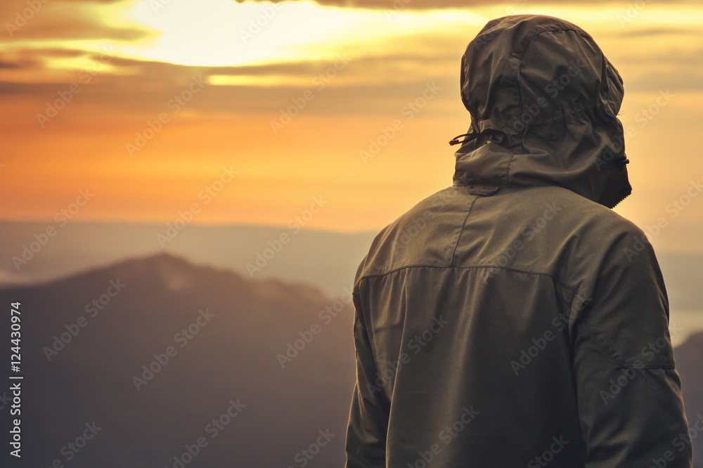 Young Man standing alone outdoor with sunset mountains on background ...