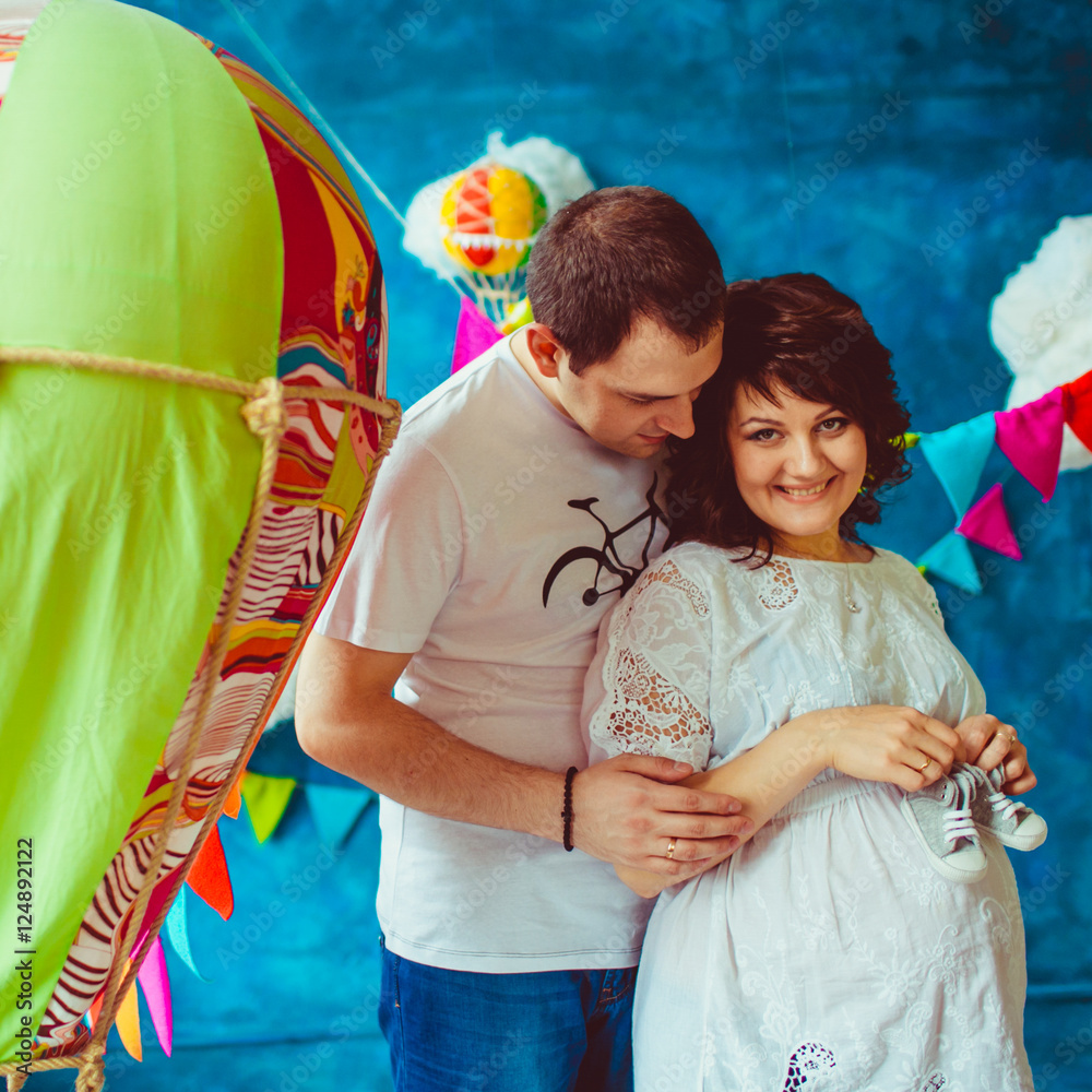 Photo Stock Tall man hugs his woman from behind while she holds grey ...