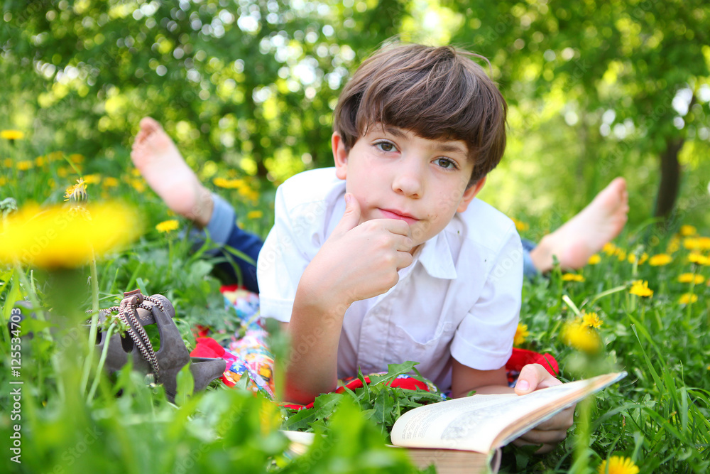 preteen boy reading book outdoor spring Stock Photo | Adobe Stock