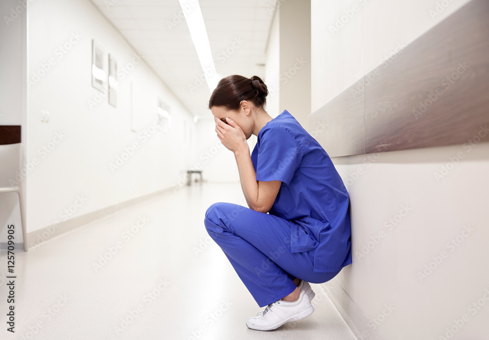 sad or crying female nurse at hospital corridor Stock Photo | Adobe Stock