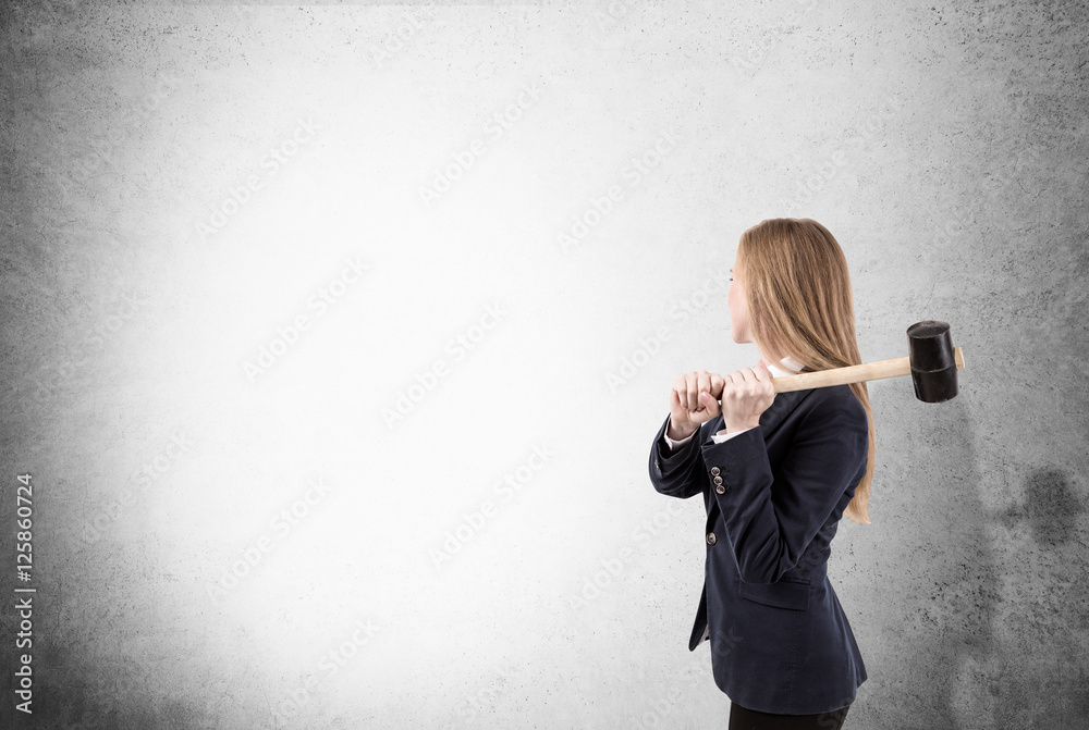 Woman is smashing concrete wall with sledgehammer Stock Photo | Adobe Stock