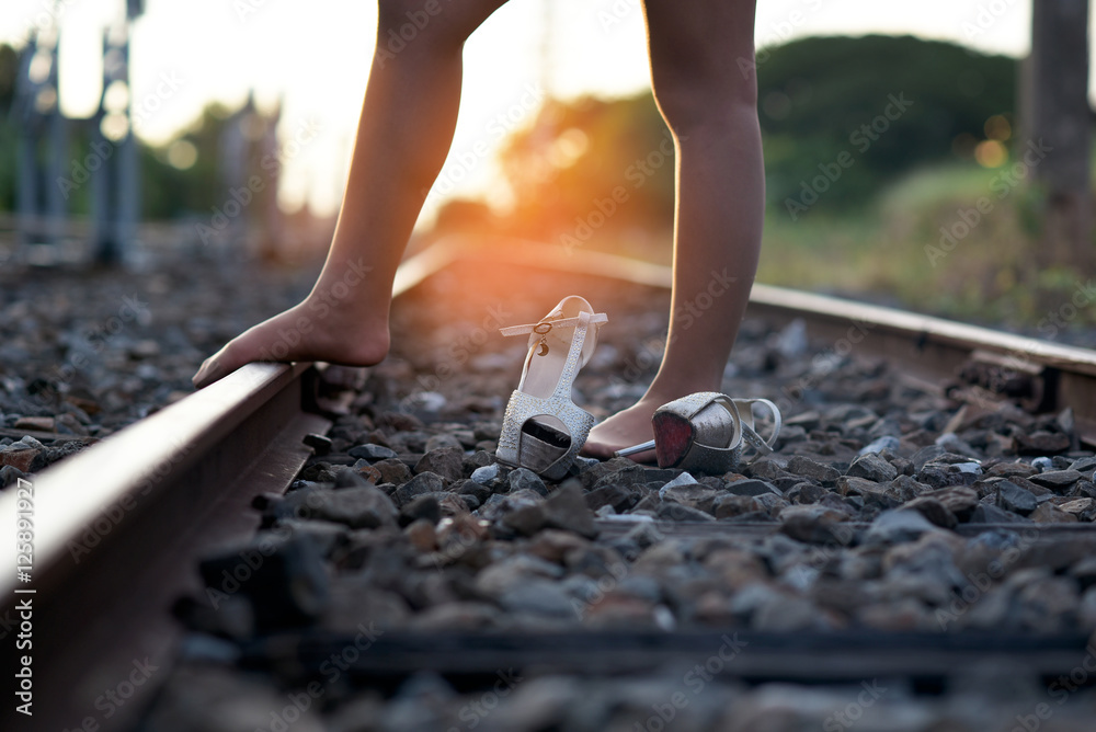 Girl's leg and loss shoe on the rail. Stock Photo | Adobe Stock