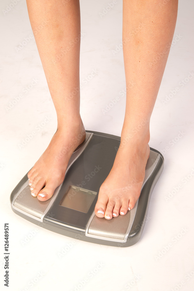 Woman's feet standing on electronic scale Stock Photo | Adobe Stock