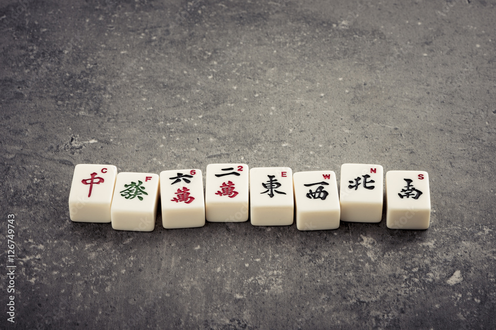 Mahjong board game pieces lying on stone table. Concept of asian or ...