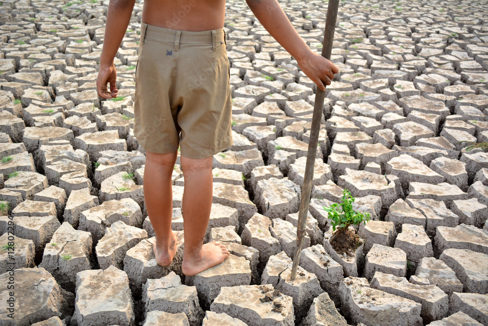 Stock-Foto „Sad a boy stand on dry ground .concept drought and hope ...