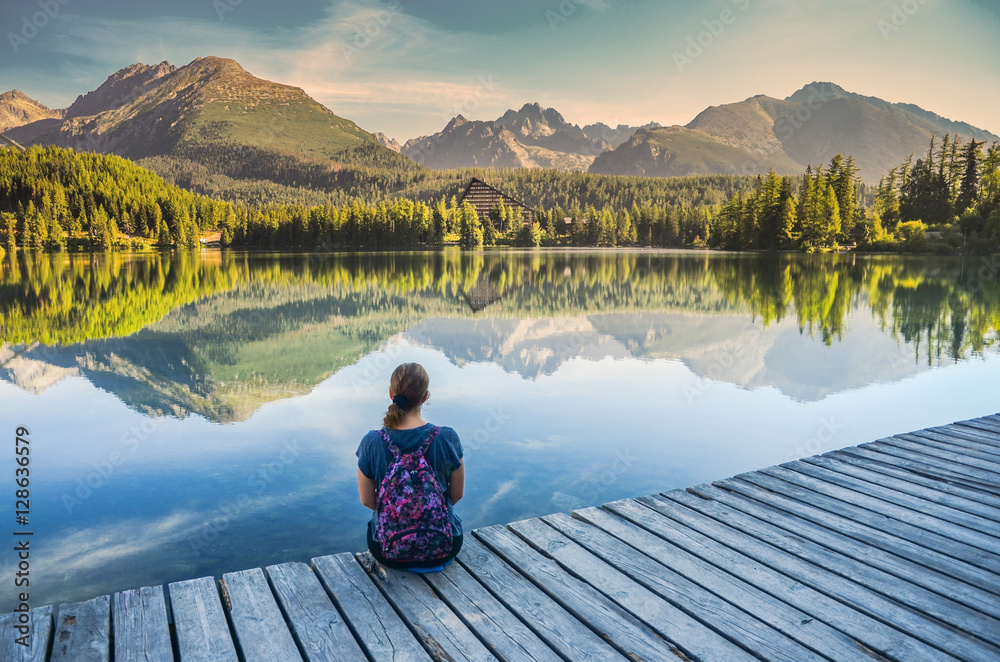 Alone young girl sitting and resting on the wooden path near by ...