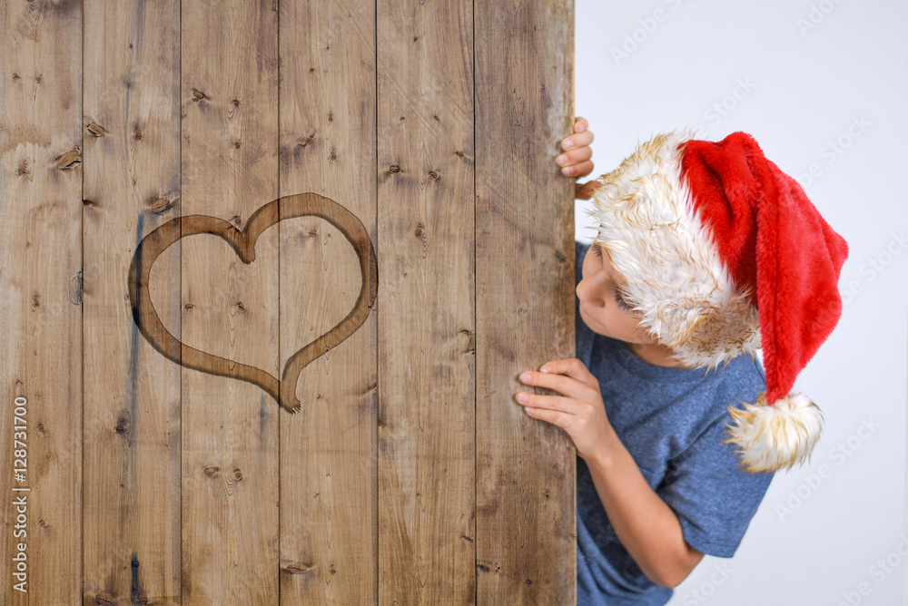 Neugieriges Kind mit Weihnachtsmütze sieht Herz an der Wand Stock Photo ...