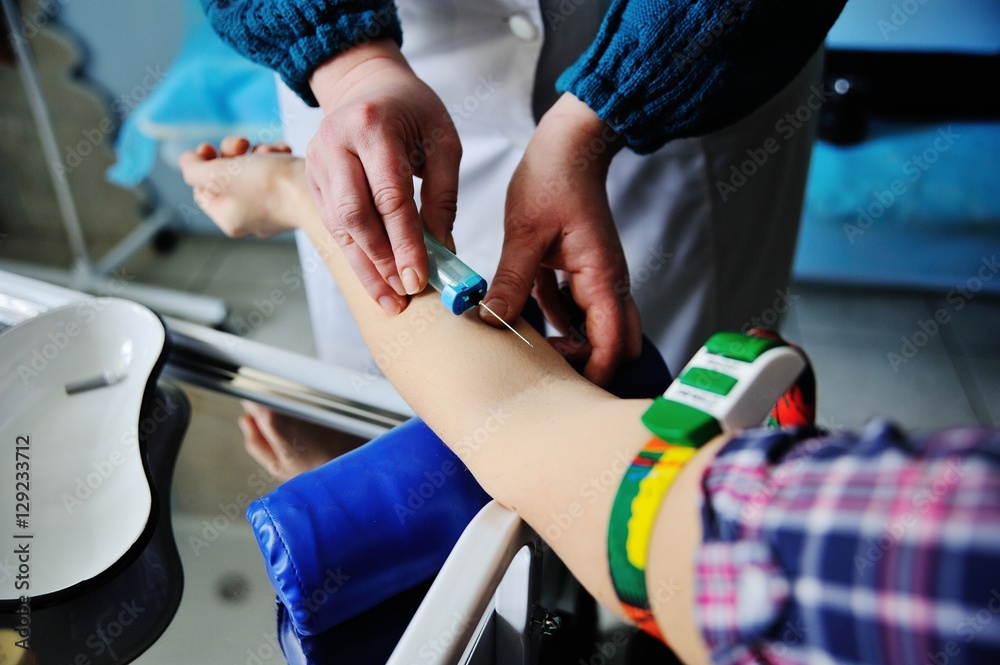 Doctor making blood analysis young girl patient. Blood sampling from a ...