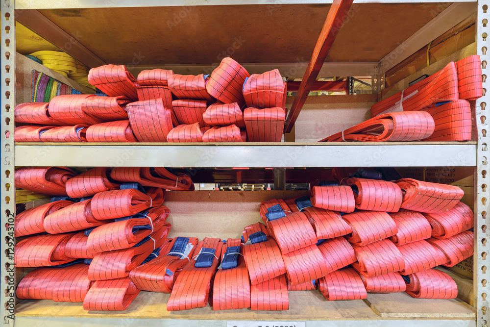 Red nylon soft lifting slings stacked in piles. Stock Photo | Adobe Stock
