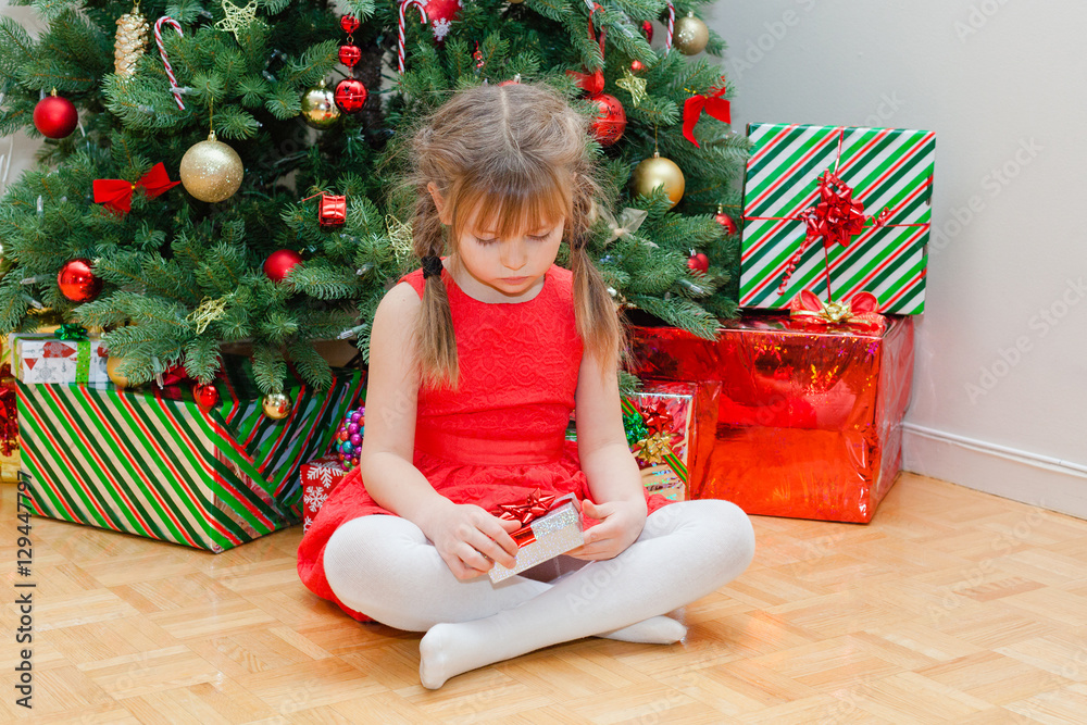 Little girl looking sad because she has got Christmas present in little ...