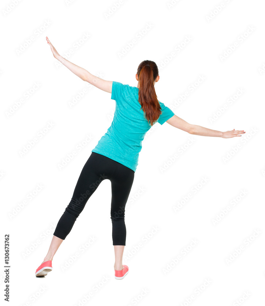 Back view woman Balances waving his arms. Standing young girl in parka ...