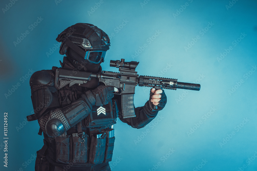 Member of the SWAT squad with an assault rifle in a black uniform on ...