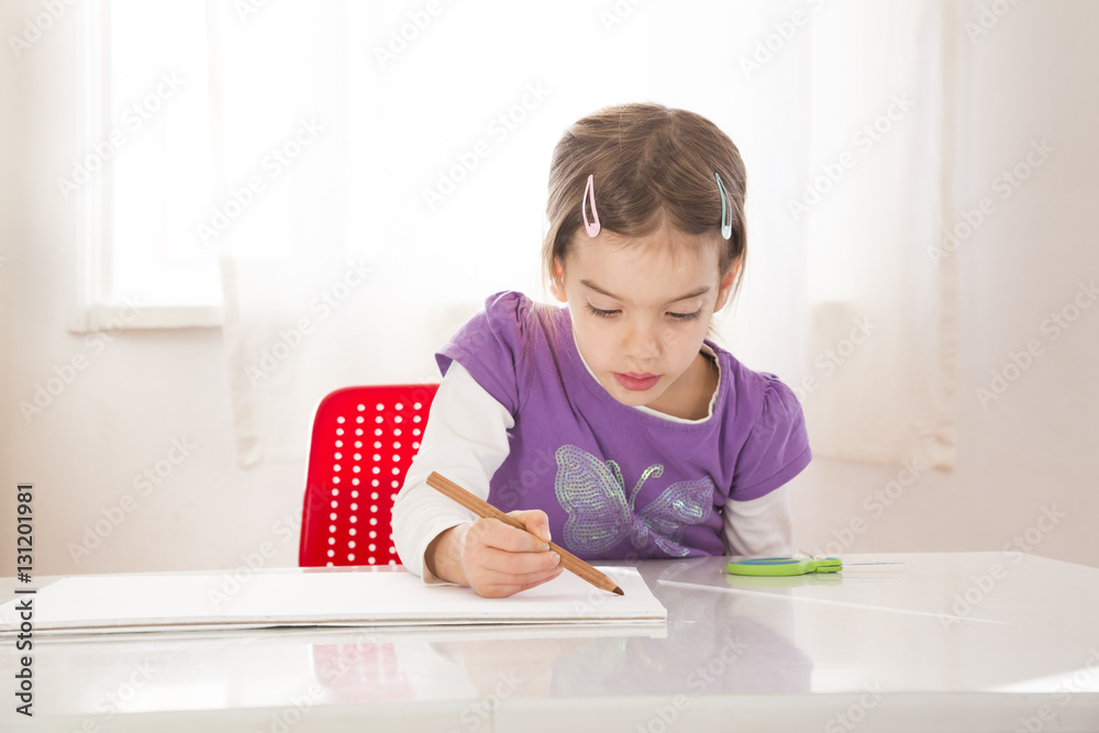 Little girl making a drawing on sheet of paper Stock Photo | Adobe Stock
