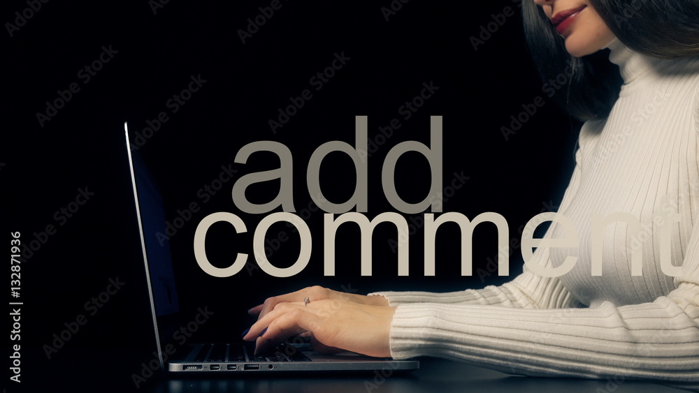 Beautiful brunette woman typing on her laptop against black background ...