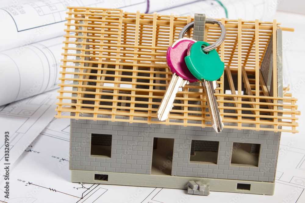 Home keys and small house under construction on electrical drawings ...