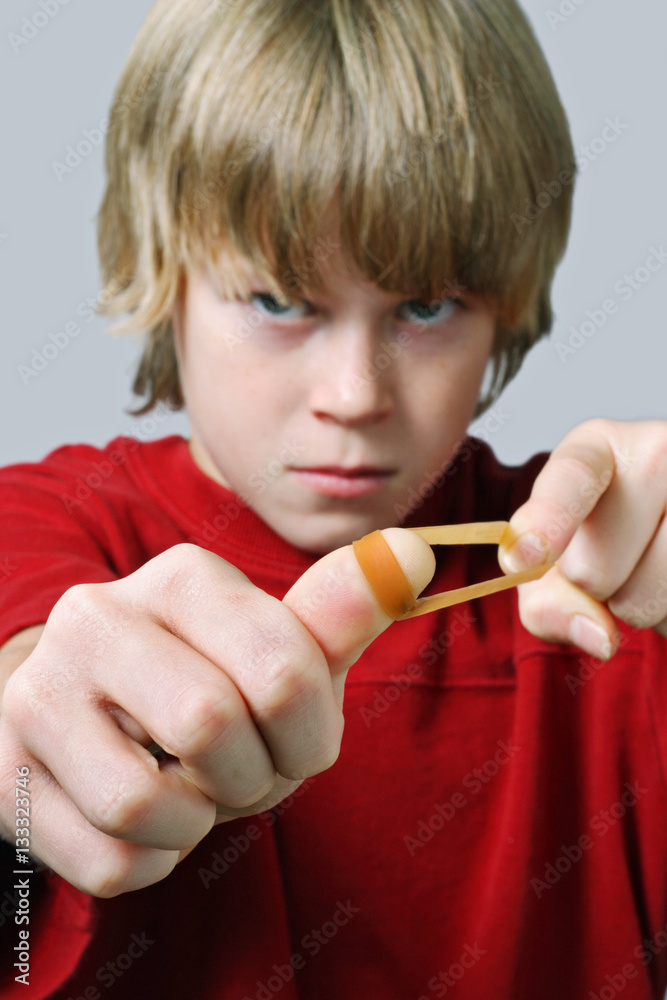 Angry Boy aiming a rubber band Stock Photo | Adobe Stock