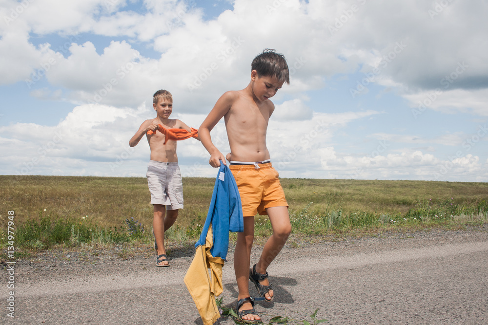 Photo Stock young boys go on the road in the field. boys in shorts ...