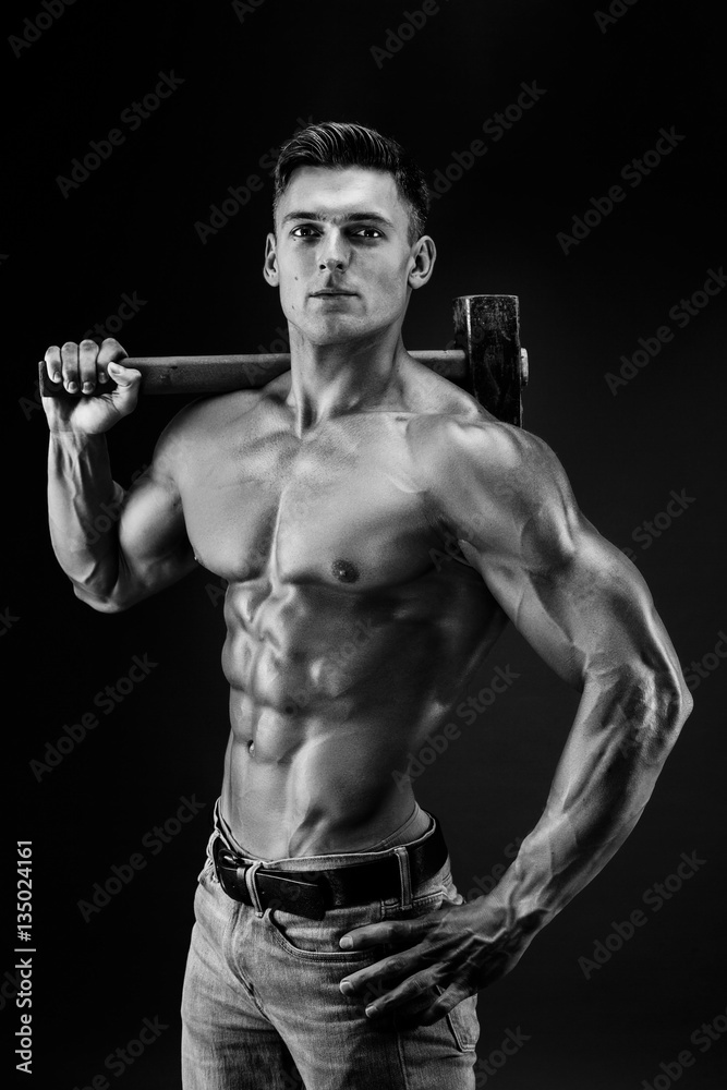 Muscular man with naked torso holding big hummer. Isolated on dark grey ...