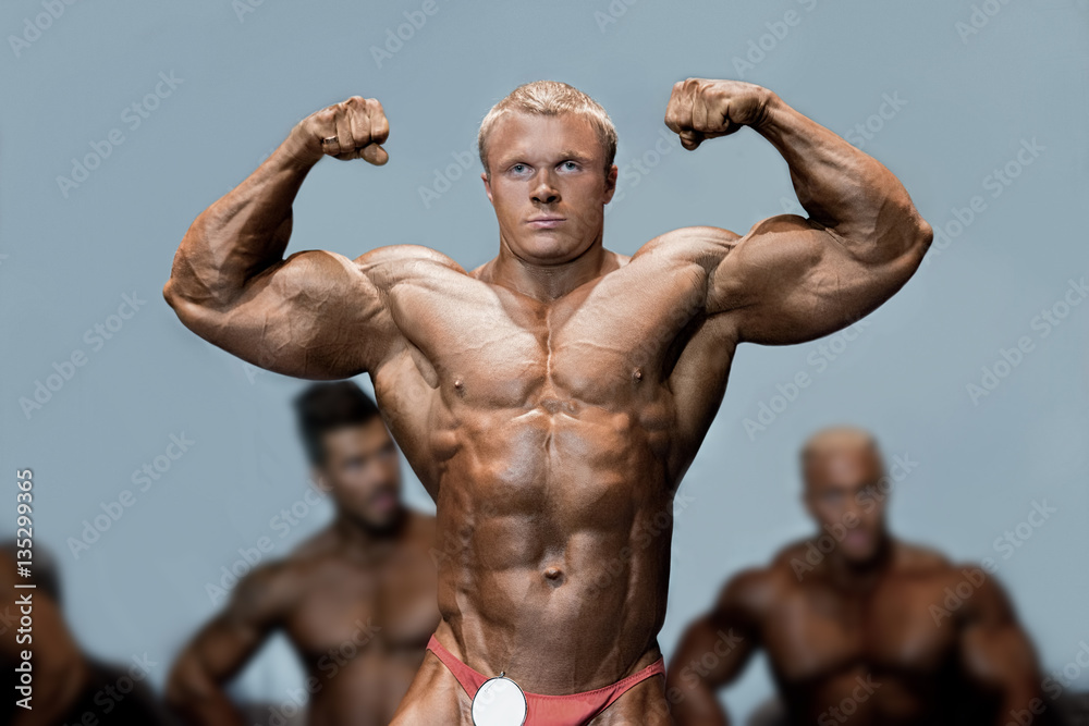 Foto de Stock Athlete's double bicep pose. Bodybuilder flexing biceps ...