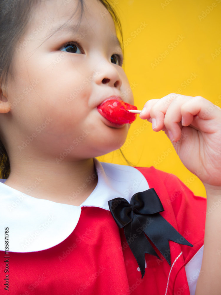 Little girls in red student dressed Eating a red popsicle Stock Photo ...