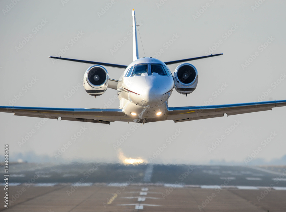 Business private jet in low level flight Stock Photo | Adobe Stock