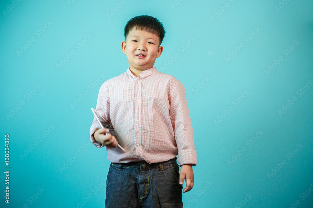 Little boy using a pad./ Child playing with digital tablet on the blue ...