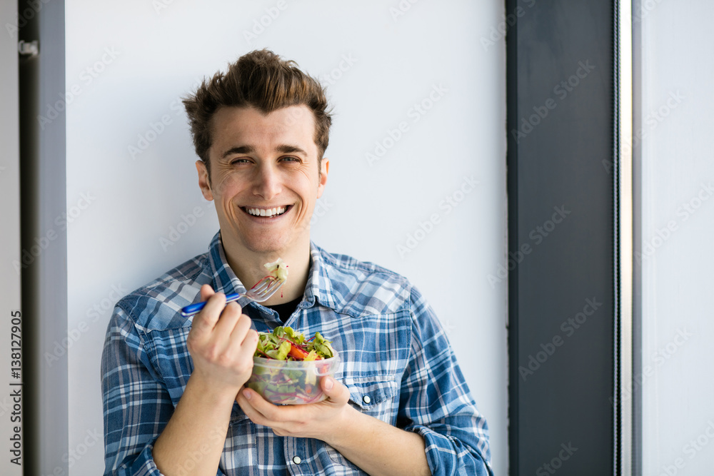 handsome young man eating salad Stock Photo | Adobe Stock
