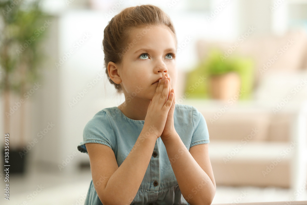 Cute little girl praying at home Stock Photo | Adobe Stock