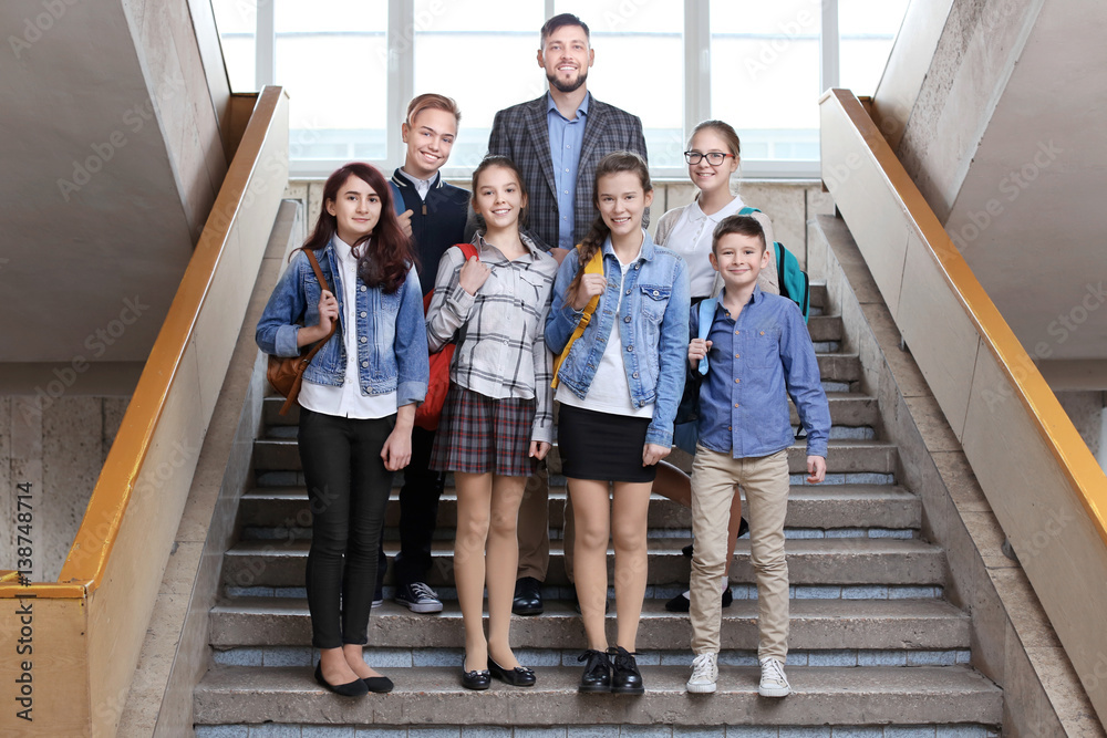 Happy pupils and teacher standing on school stairs Stock Photo | Adobe ...