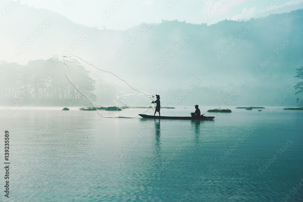 Fisherman casting out his fishing net in the river by throwing it into ...