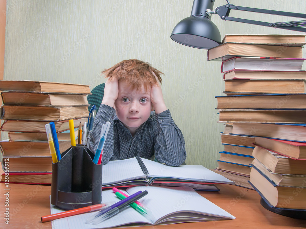 student doing homework, a large pile of books. Stock Photo | Adobe Stock