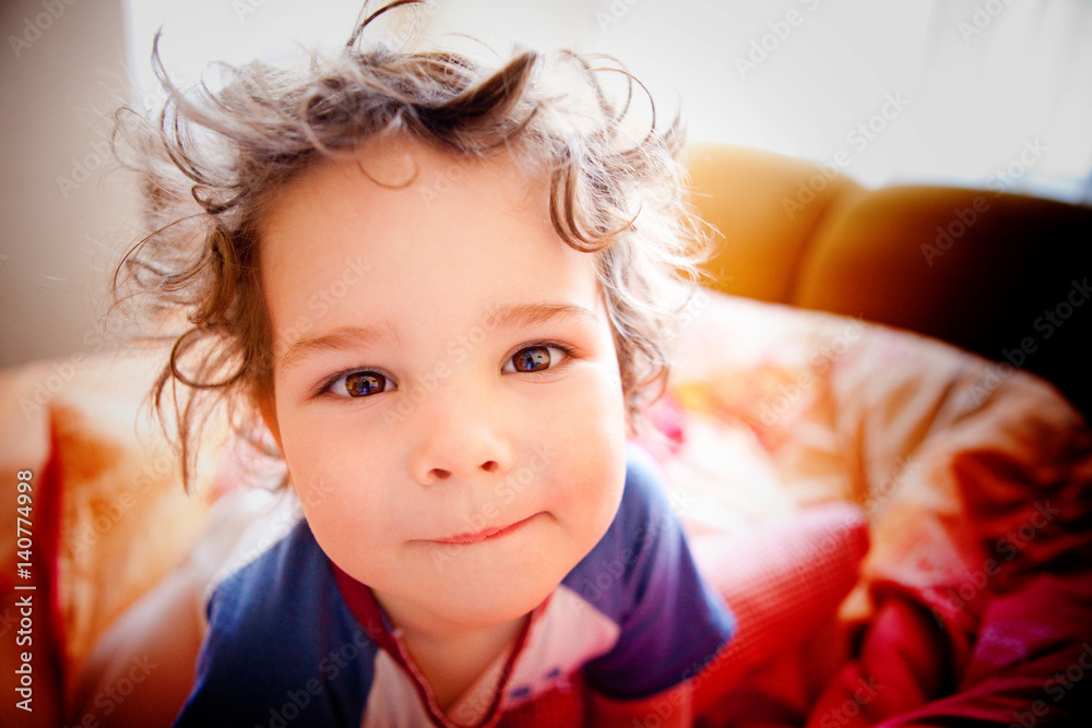 Shaggy child peeks into the camera Stock Photo | Adobe Stock