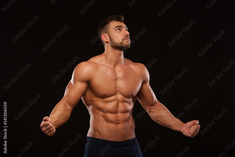 Strong Athletic Man Fitness Model Torso showing six pack abs. isolated on black background with ...