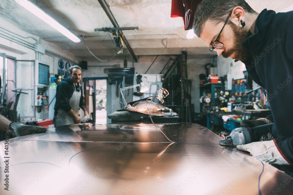 Metalworker gouging sheet copper at forge workbench Stock Photo | Adobe ...