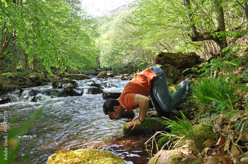 Man drinking water from the river. Clean unpolluted water in the river ...