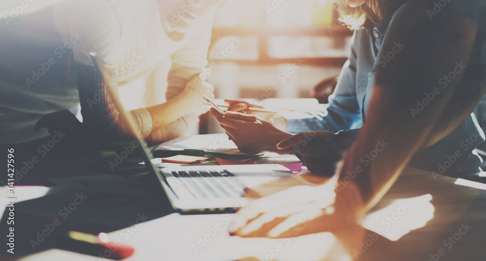 Group of young coworkers working together at modern office at sunset ...