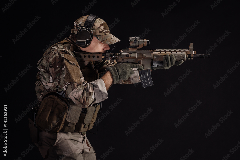 Portrait soldier or private military contractor holding sniper rifle ...